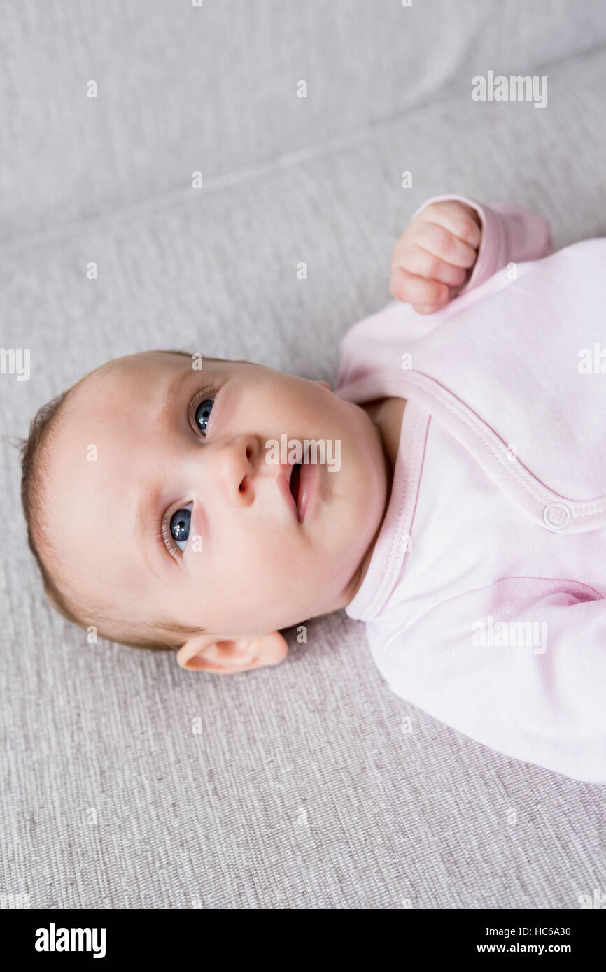 Baby lying on sofa in living room Stock Photo - Alamy