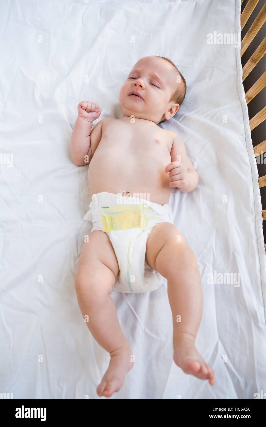Baby lying on baby bed Stock Photo - Alamy