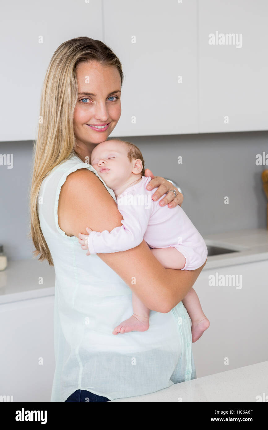 Mother carrying her baby in kitchen at home Stock Photo - Alamy