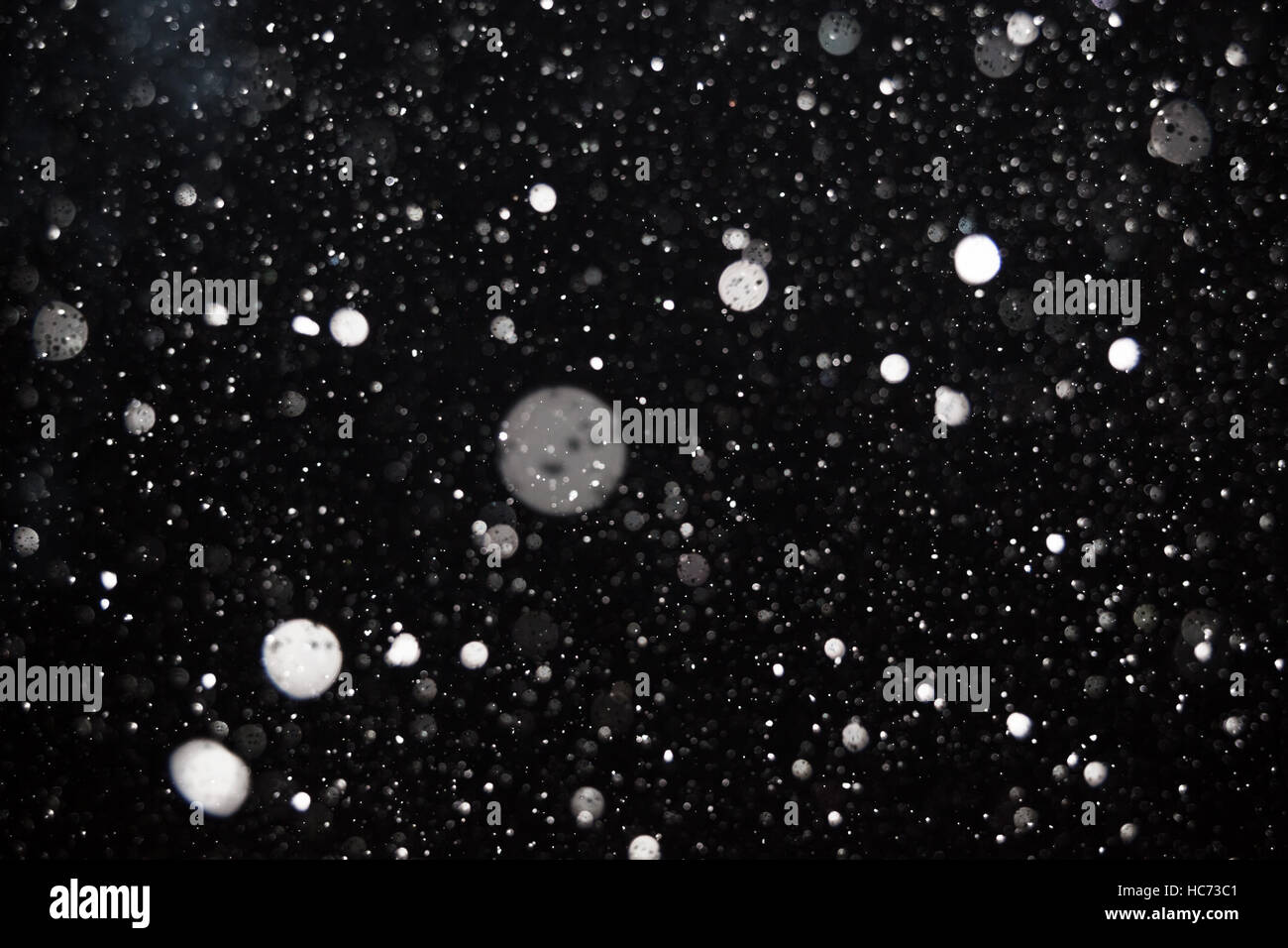 Falling snow on black background Stock Photo - Alamy