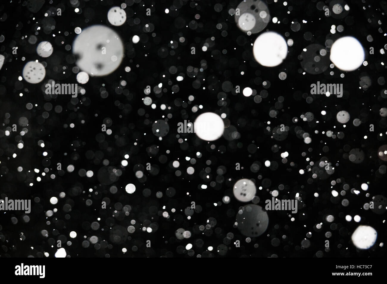 Falling snow on black background Stock Photo - Alamy
