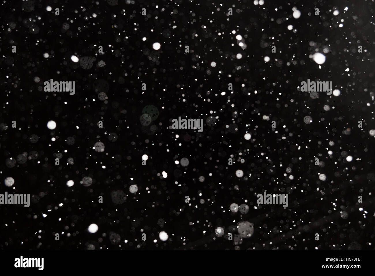 Falling snow on black background Stock Photo - Alamy