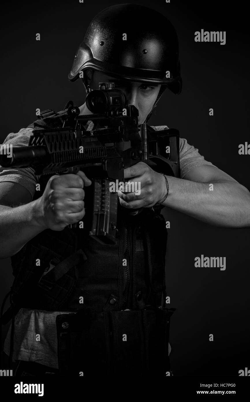 Warfare, paintball sport player wearing protective helmet aiming pistol ...