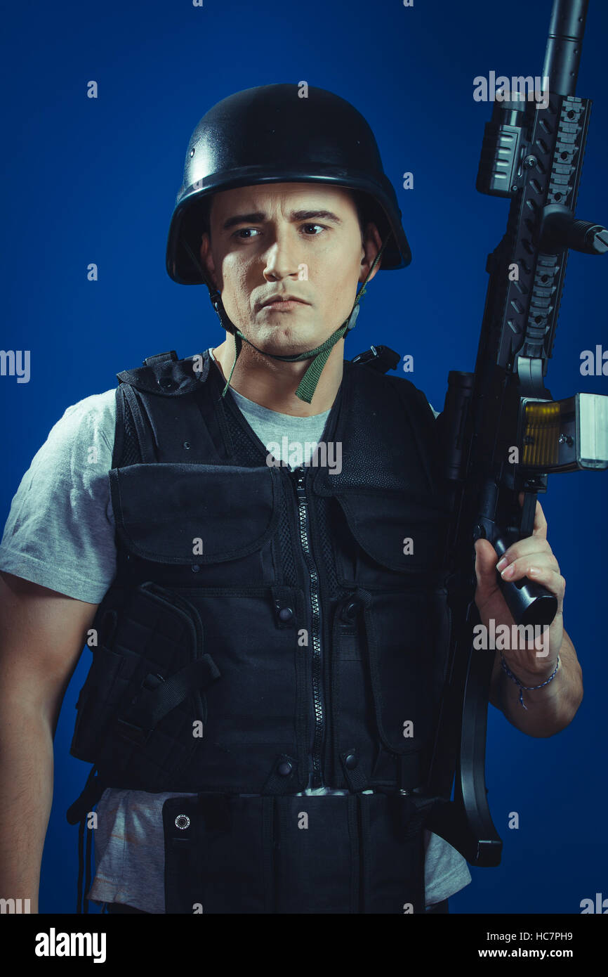 gamer wearing protective helmet aiming pistol ,black armor and machine ...