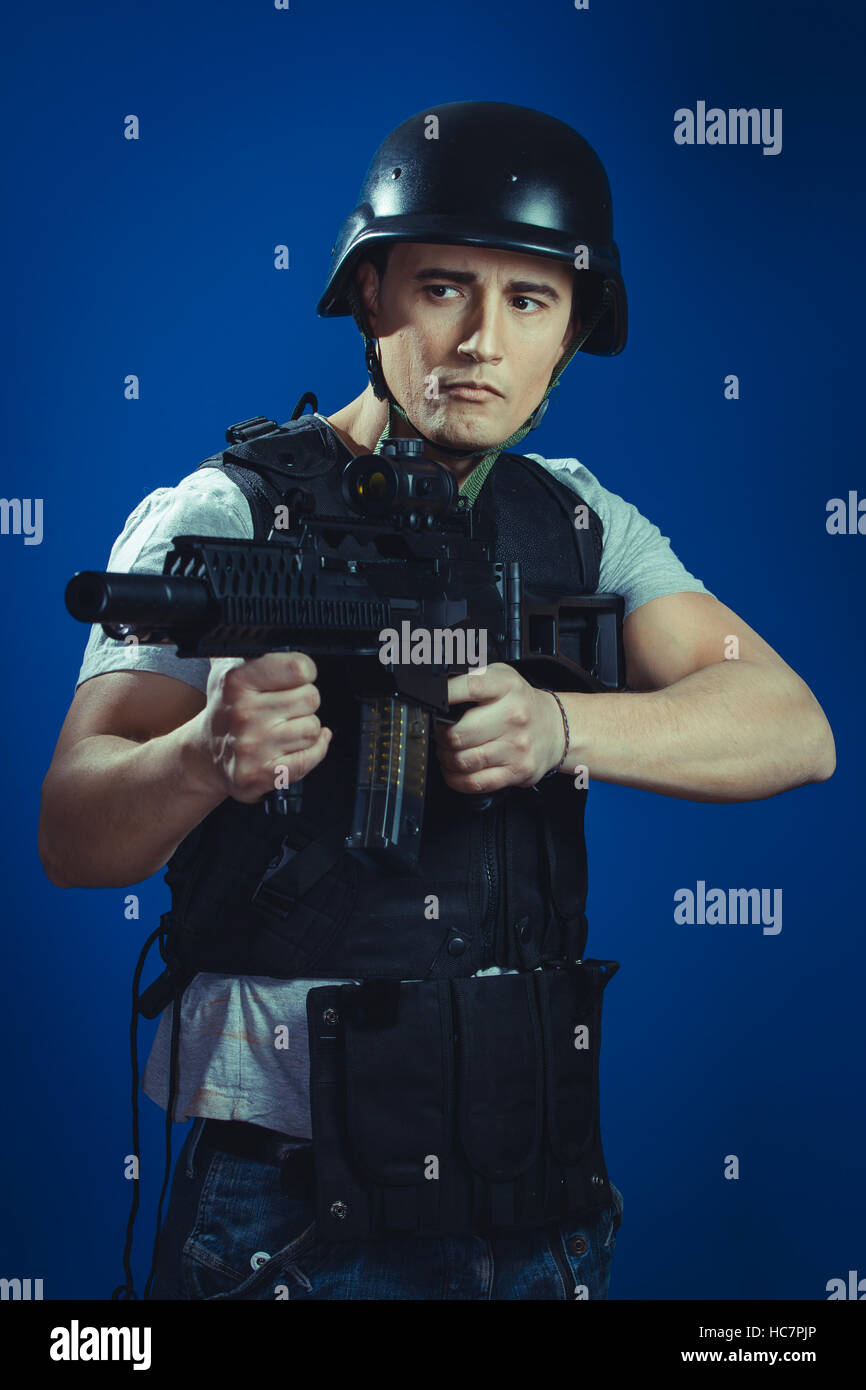 Security, paintball sport player wearing protective helmet aiming ...