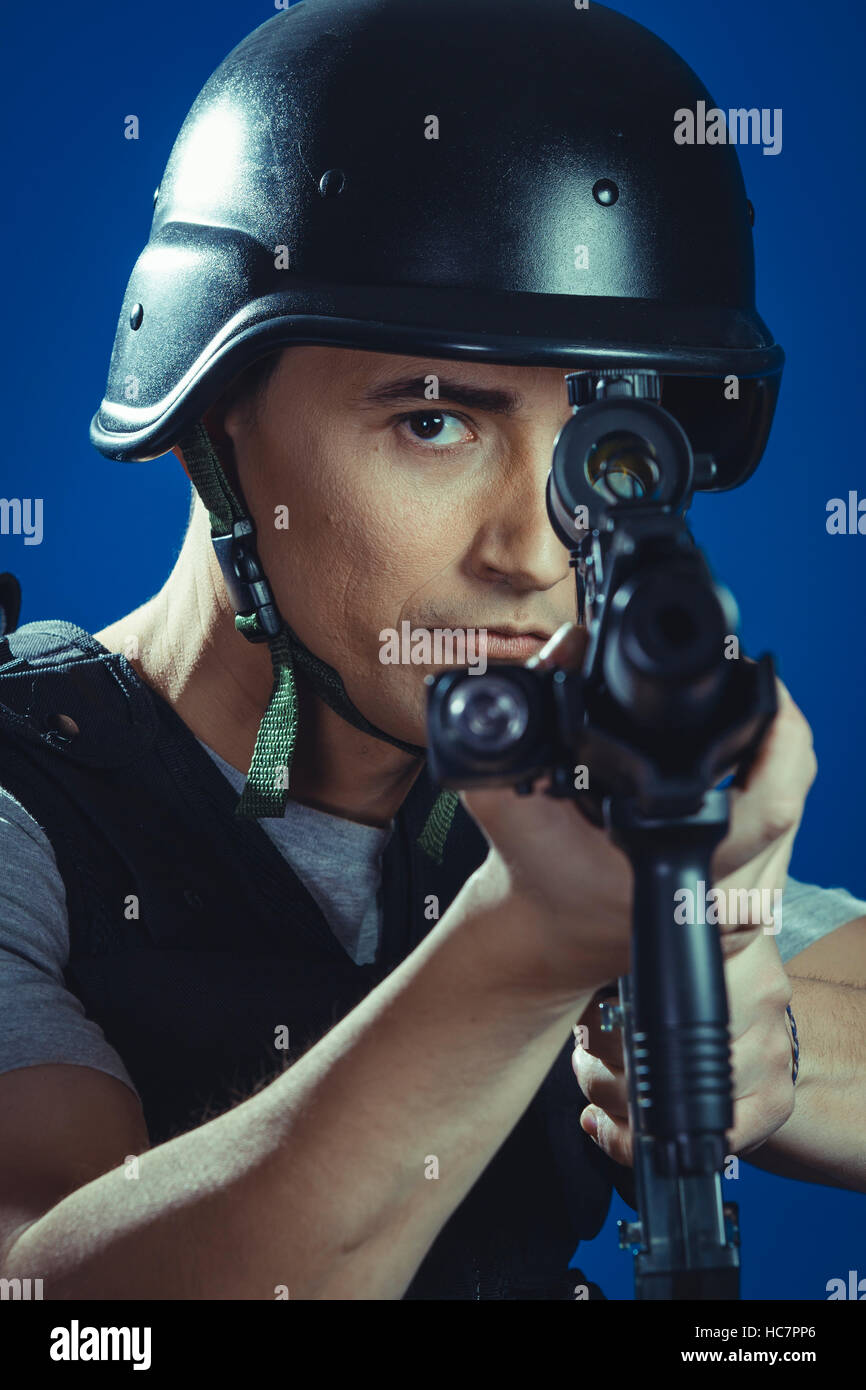 Weapon, paintball sport player wearing protective helmet aiming pistol ...