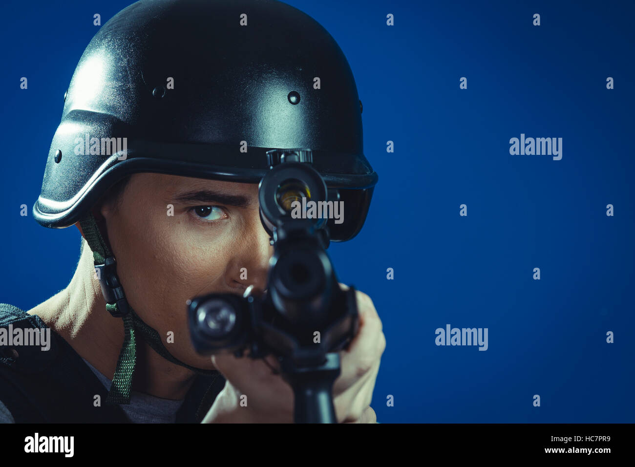 Police, paintball sport player wearing protective helmet aiming pistol ...