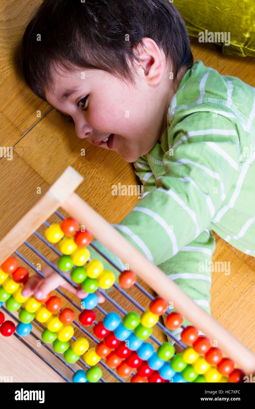 Funny little boy playing with abacus, studio shot Stock Photo - Alamy