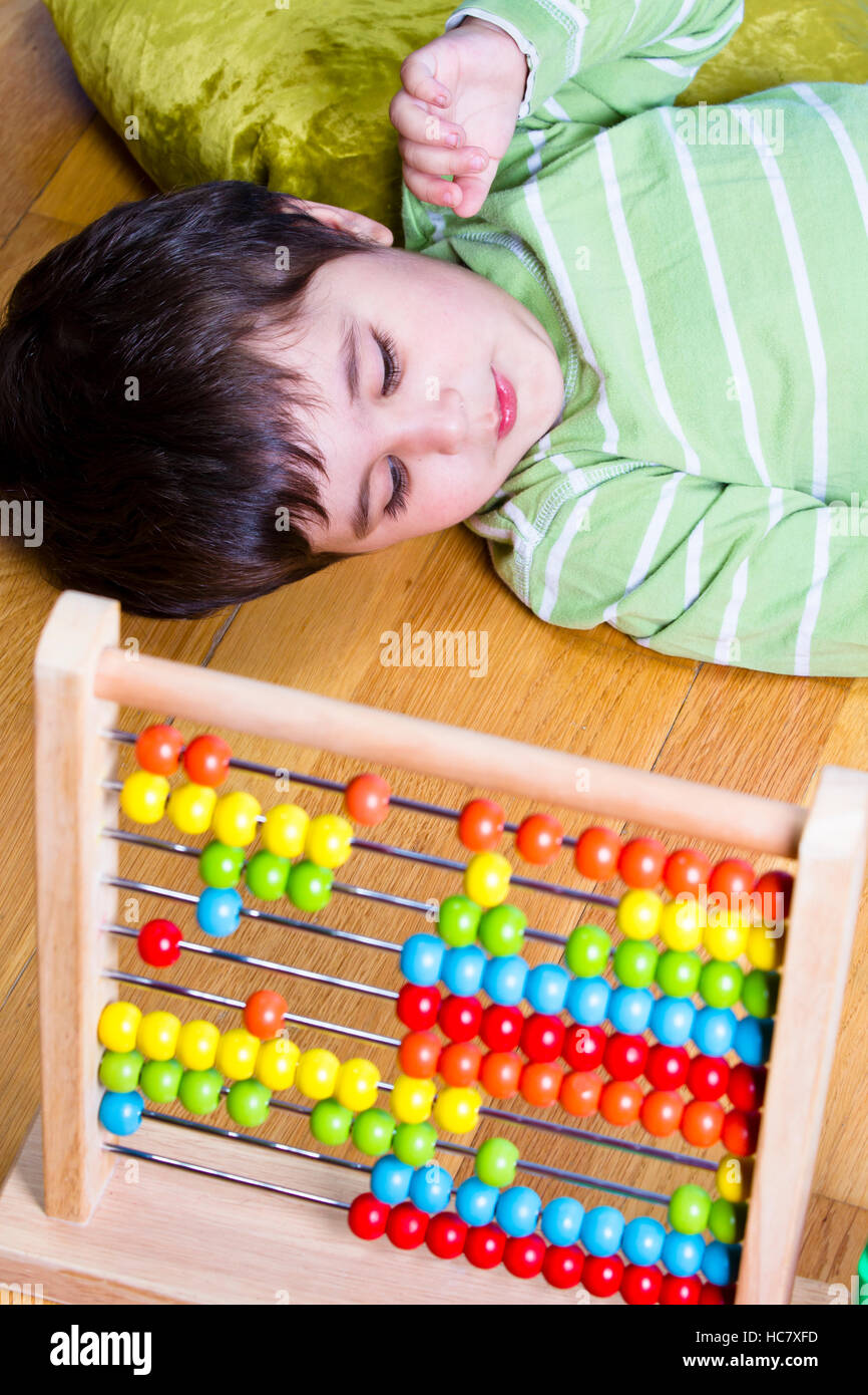 Funny little boy playing with abacus, studio shot Stock Photo - Alamy