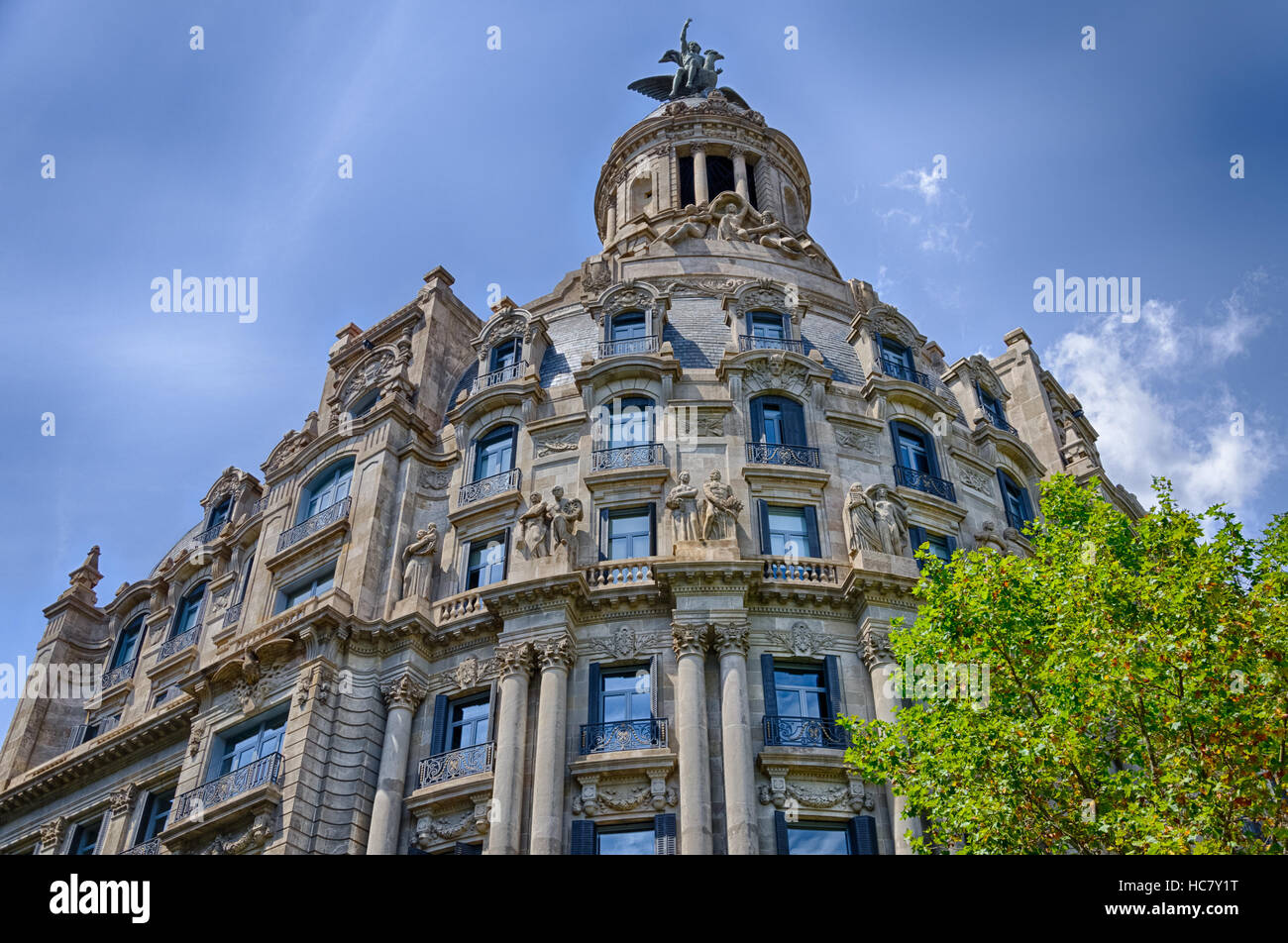 Interesting facade with statues on blue sky background in Barcelona ...