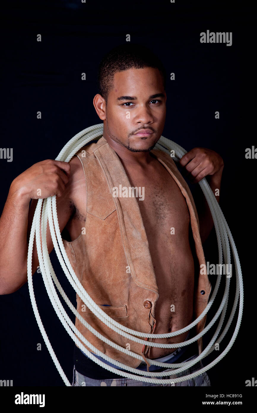 Handsome black man in a leather vest and working with a lasso Stock ...
