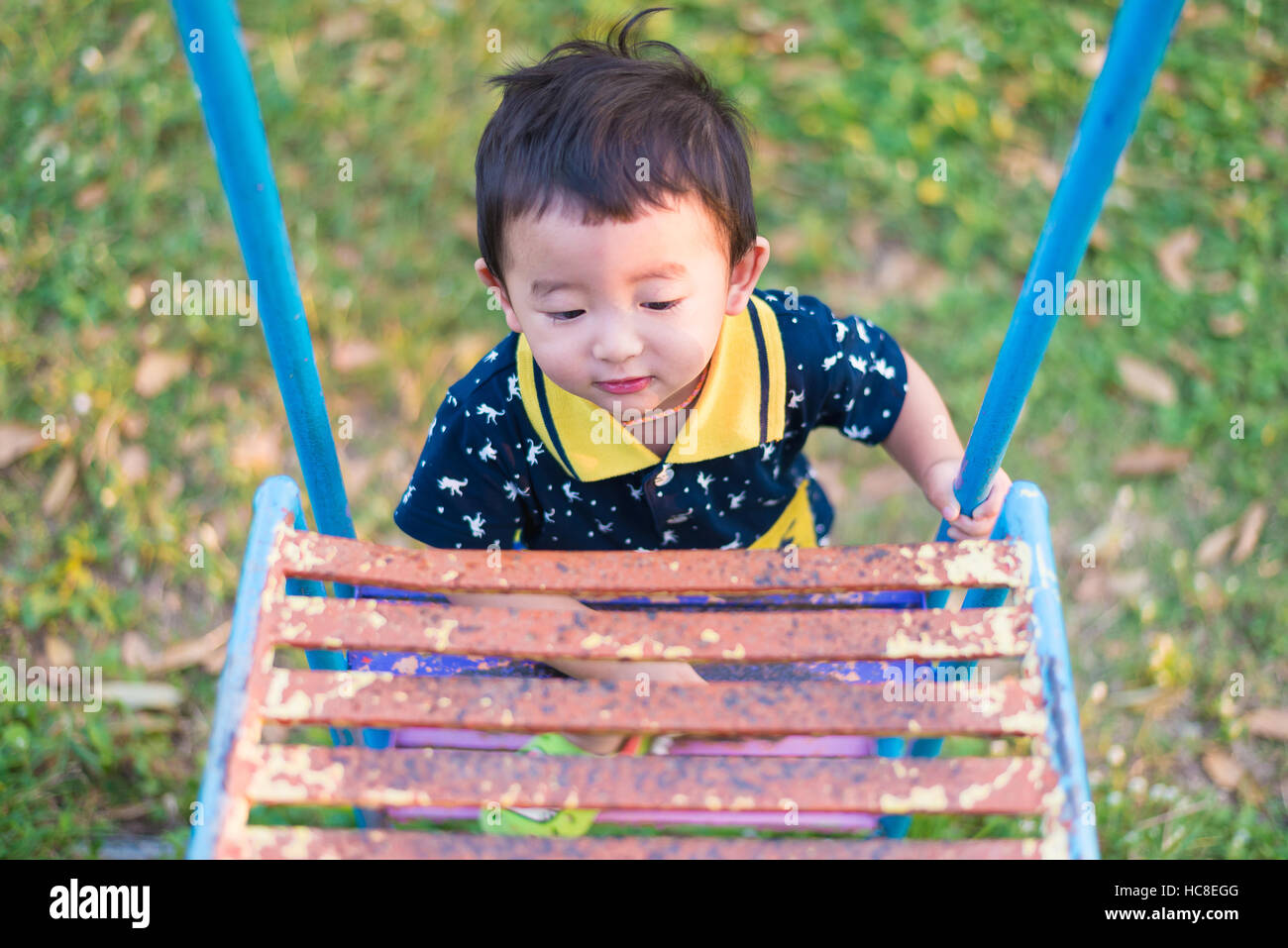 Asian kid goes up the stairs in the park. concept of growing up. step ...