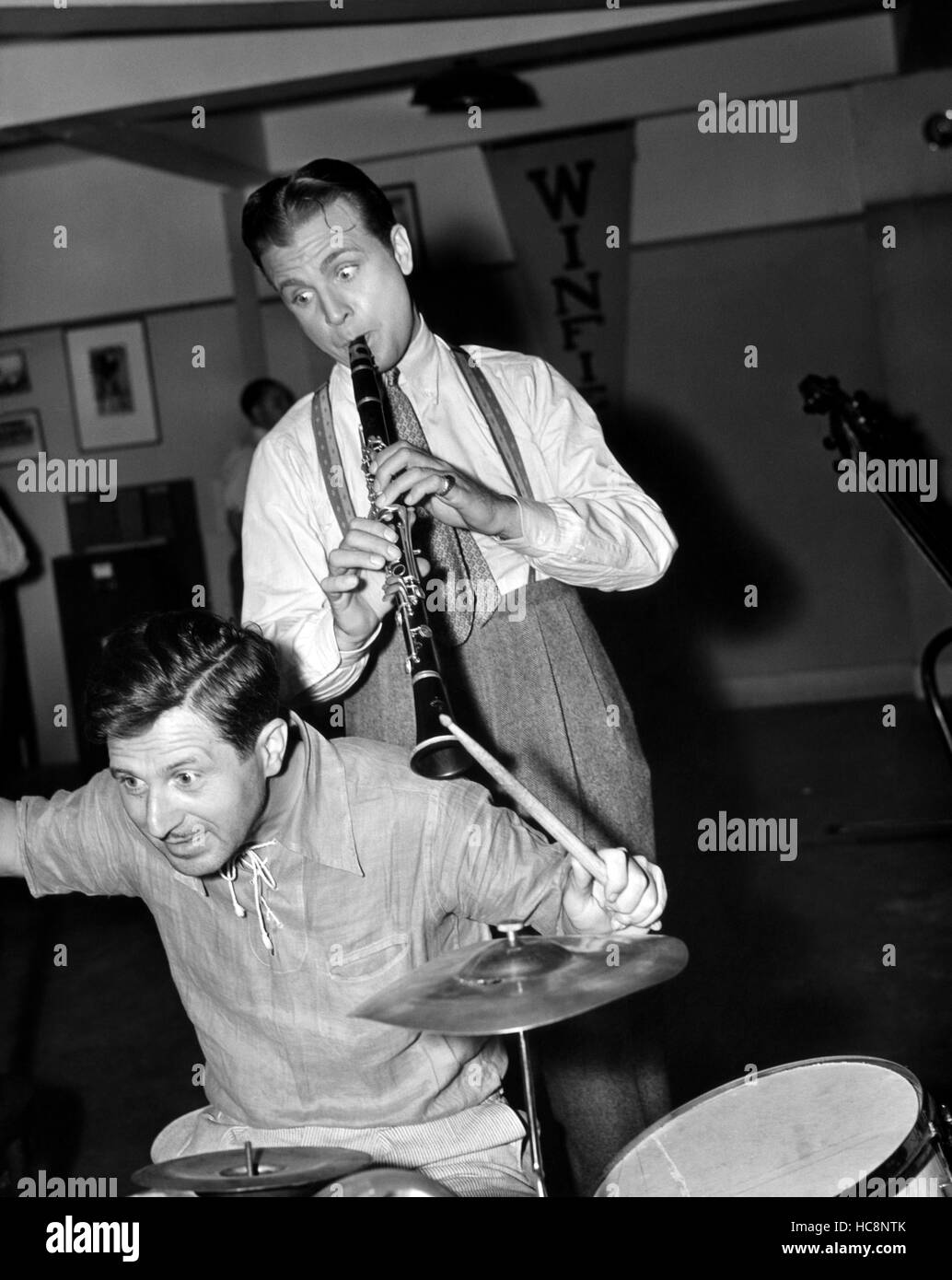 VARSITY SHOW, Dick Powell (standing) clowning with camerman Sol Polito ...