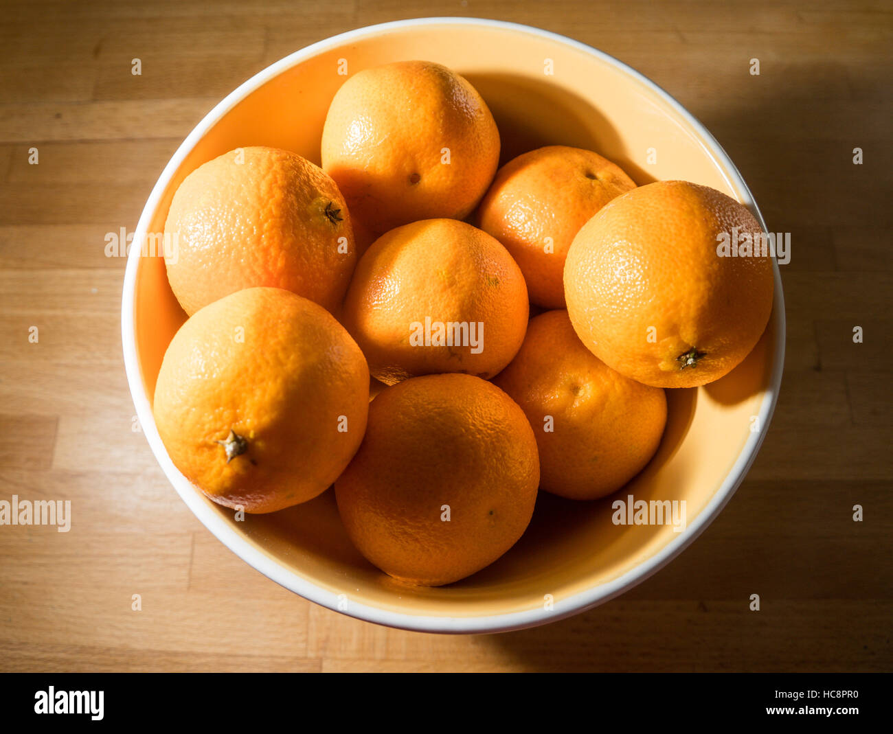 Clementine oranges in a bowl on a wooden counter Stock Photo - Alamy