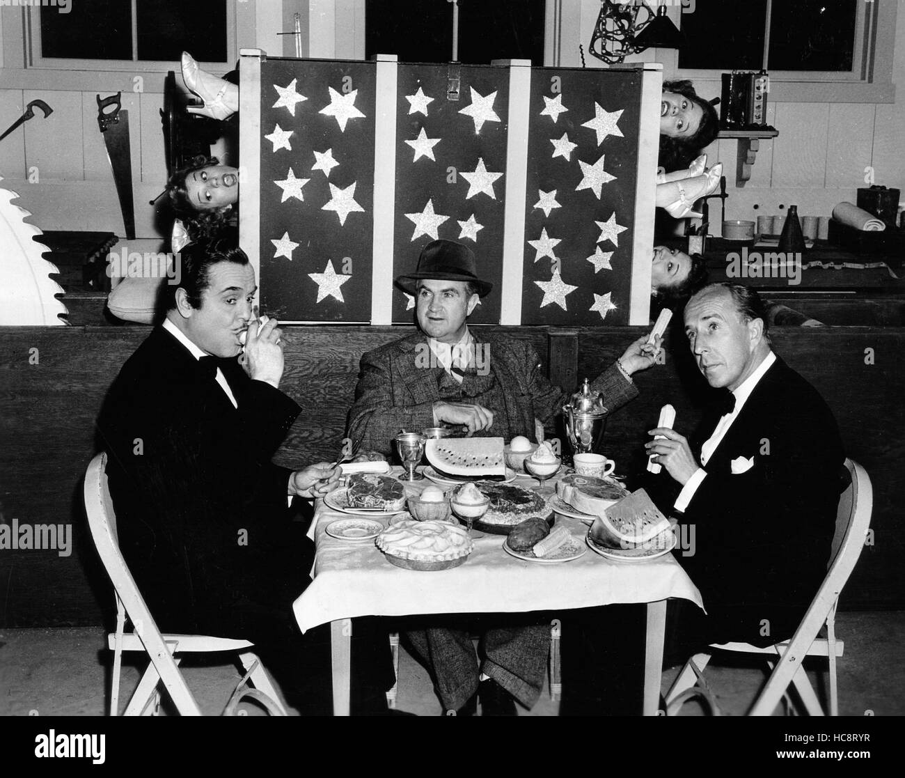 WHAT'S COOKIN?, director Edward Cline (ctr) dines with Leo Carrillo (l ...