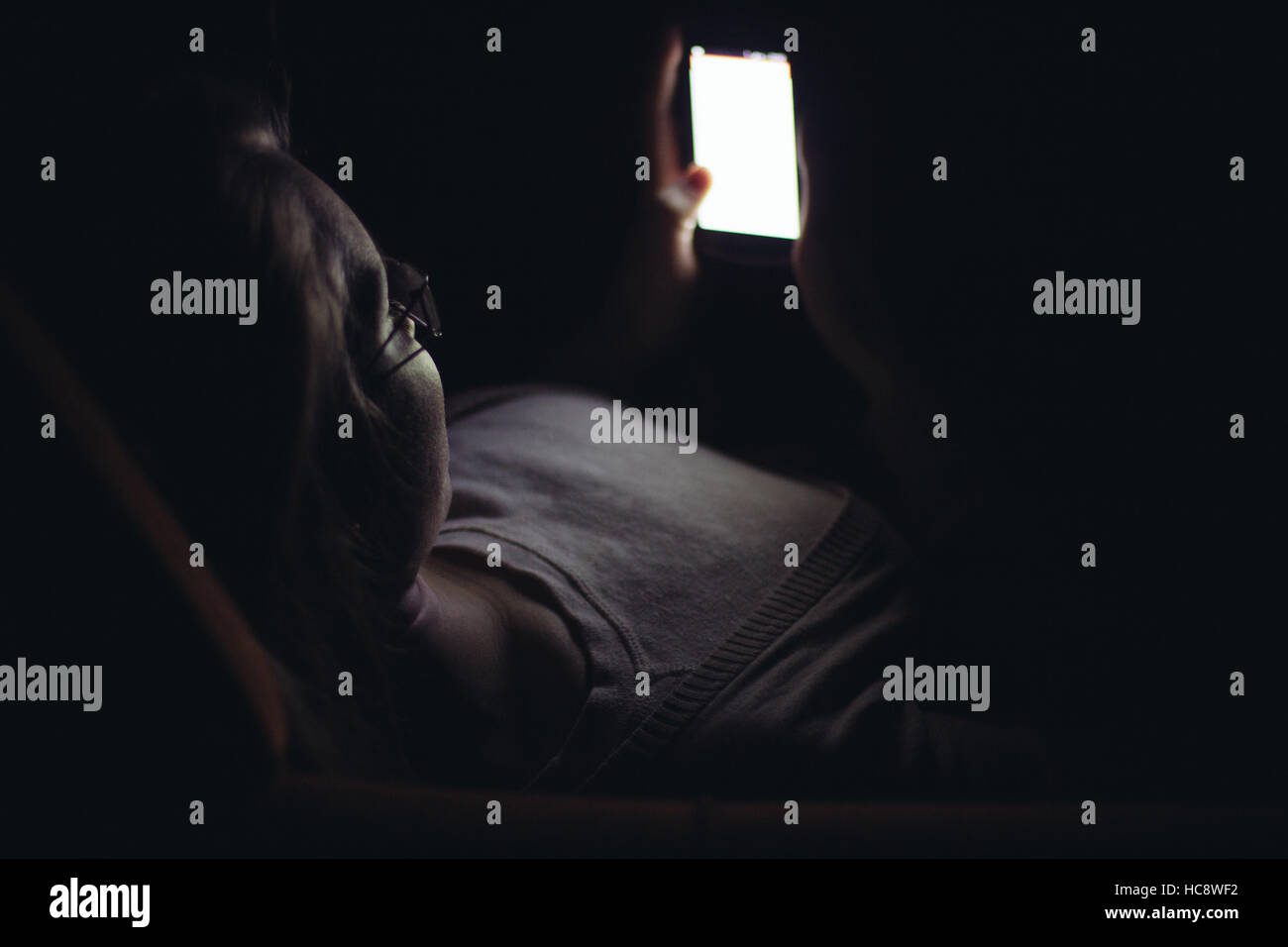 Young woman using mobile phone in dark room at home Stock Photo - Alamy