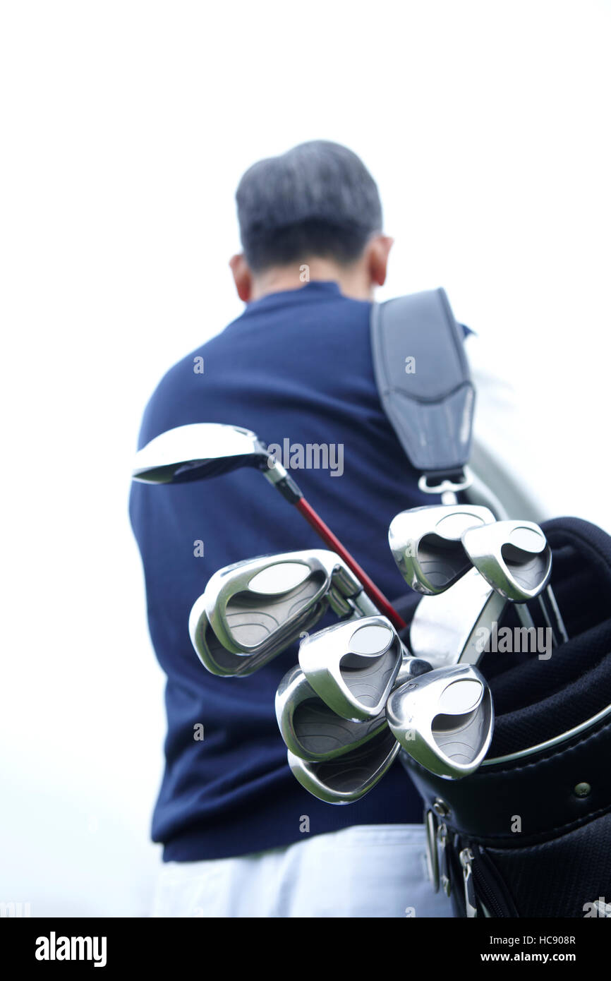 Back of old man with golf clubs in field Stock Photo - Alamy