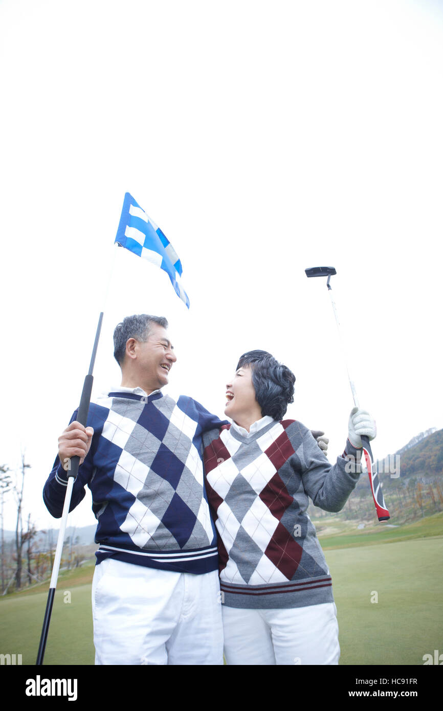 Smiling senior couple golfers hugging face to face Stock Photo - Alamy