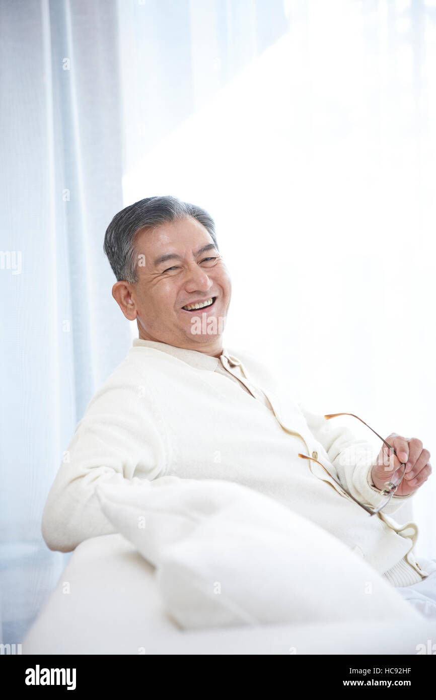 Portrait of smiling old man resting indoors Stock Photo - Alamy