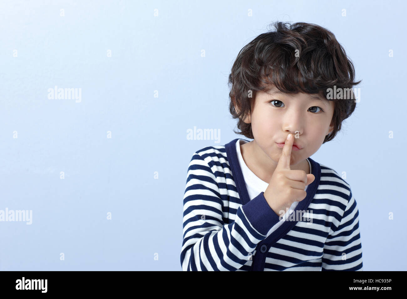 Portrait of boy with hush sign Stock Photo - Alamy