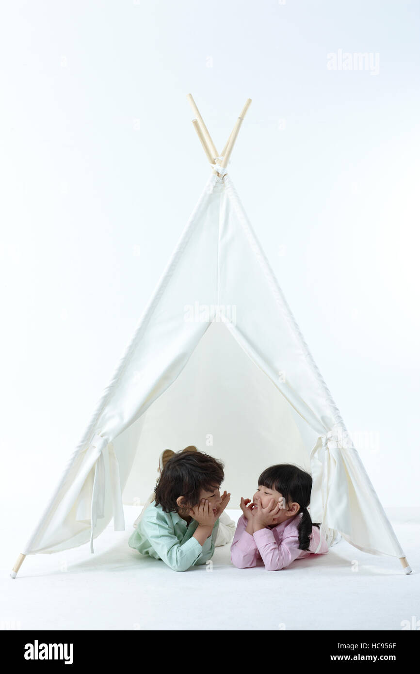Smiling boy and girl playing in a tent Stock Photo - Alamy