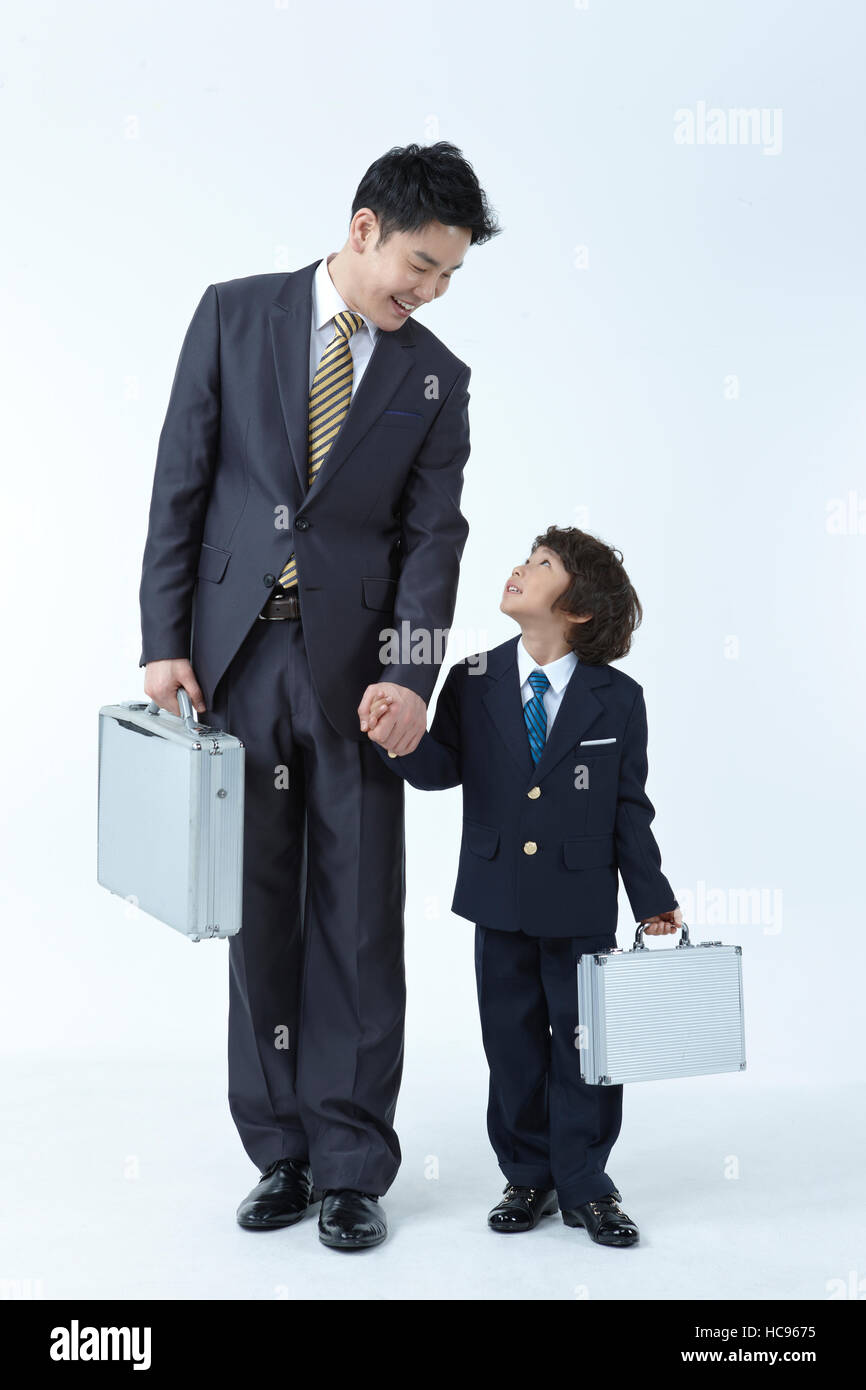Smiling father and son in suits standing holding briefcases Stock Photo ...