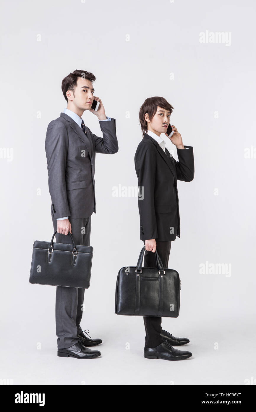 Businessman and woman disguising herself as businessman with briefcases ...