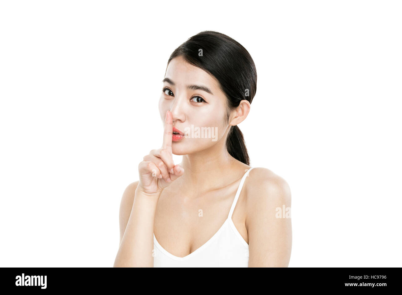 Portrait of young smiling woman with hush sign Stock Photo - Alamy
