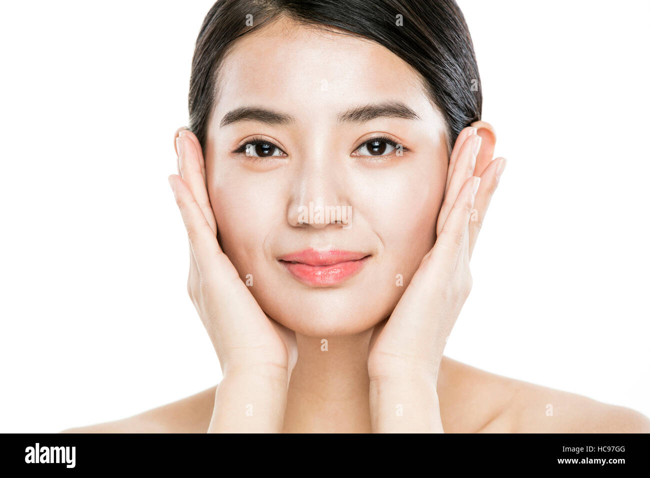 Portrait of young smiling woman massaging face Stock Photo - Alamy
