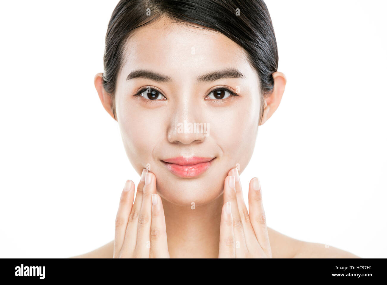 Portrait of young smiling woman massaging face Stock Photo - Alamy