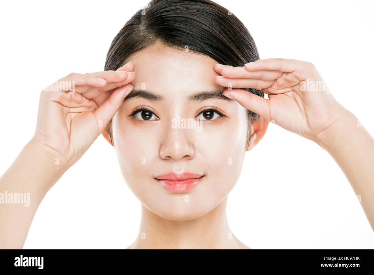 Portrait of young smiling woman massaging face Stock Photo - Alamy
