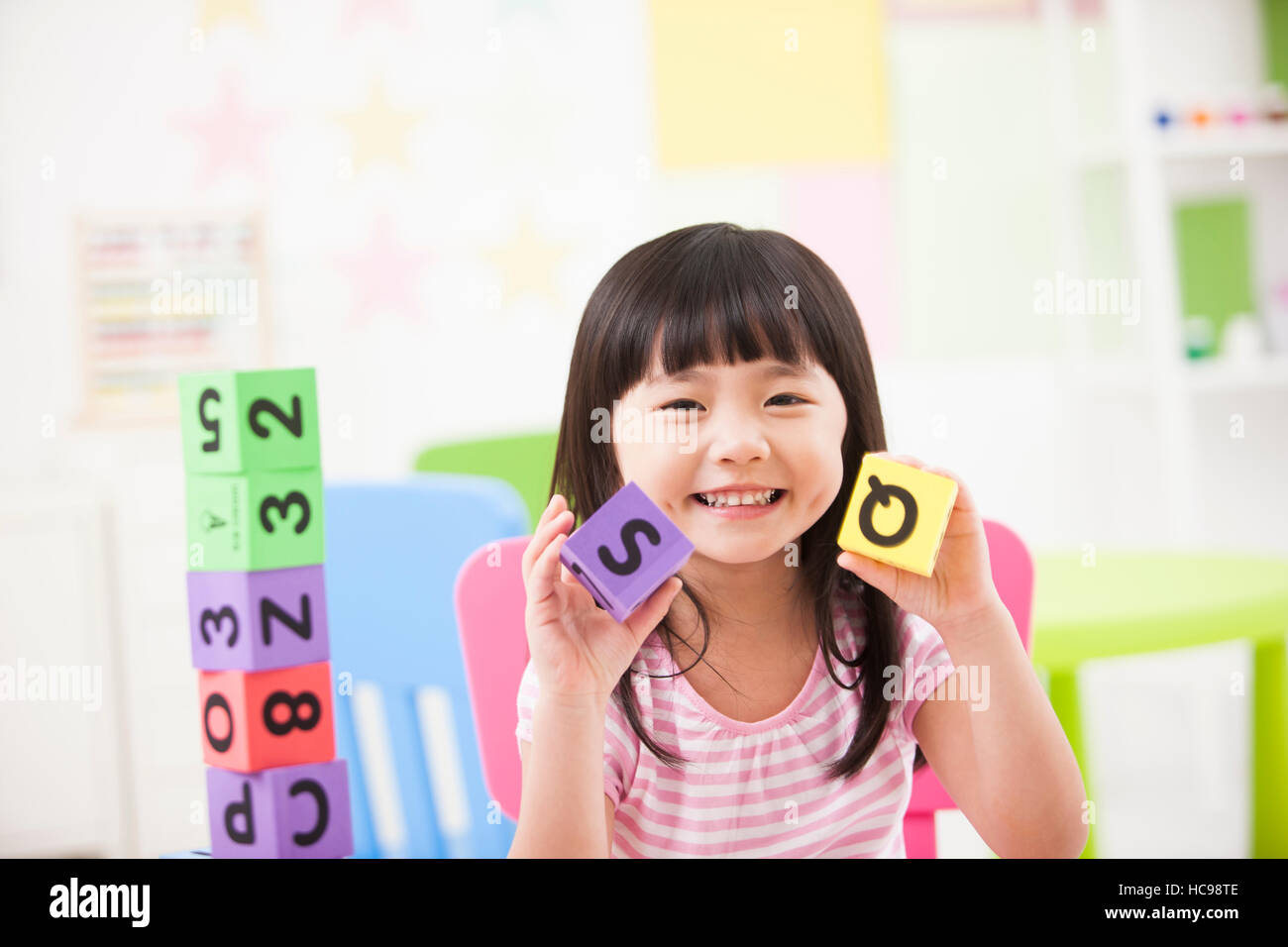 Portrait of smiling girl playing with alphabet blocks Stock Photo - Alamy