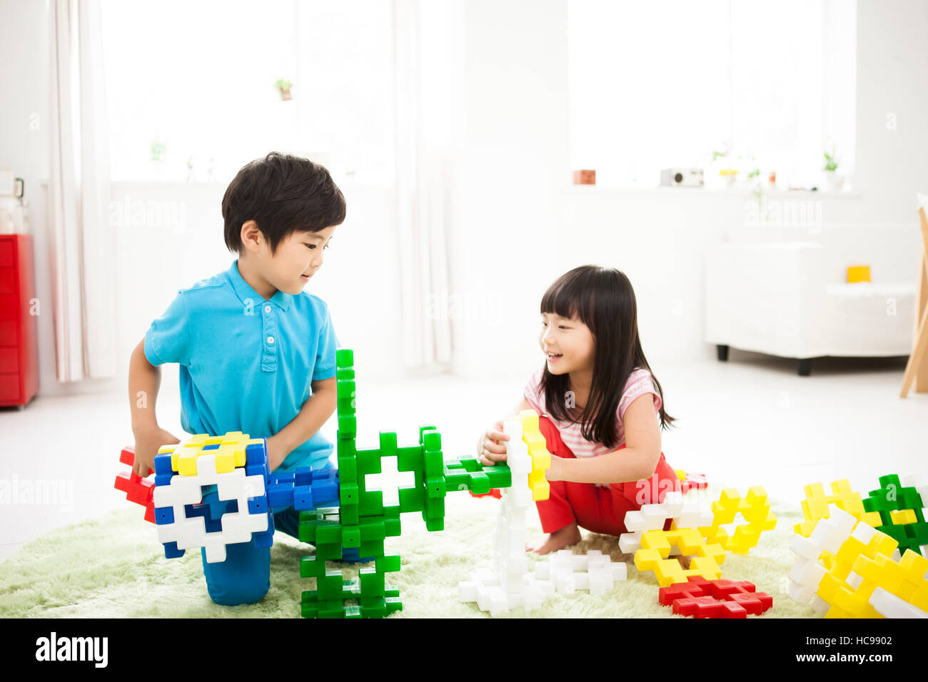 Two children playing with blocks indoors Stock Photo - Alamy