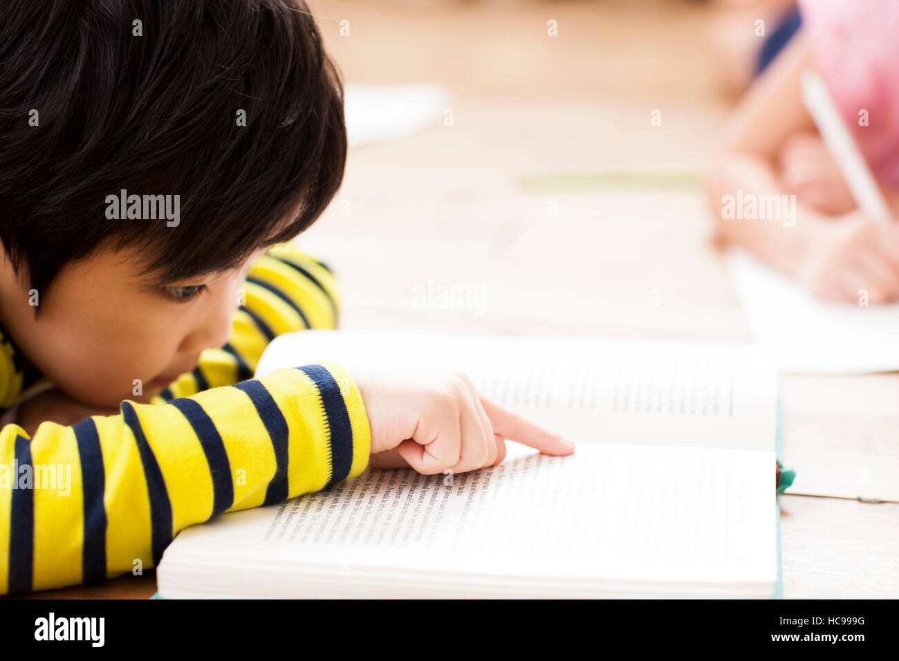 Side view of boy reading a book Stock Photo - Alamy