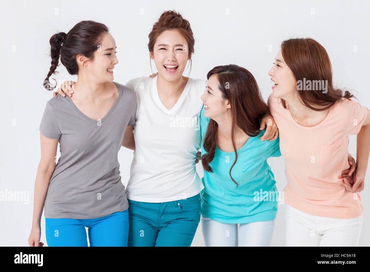 Four young smiling women posing Stock Photo - Alamy