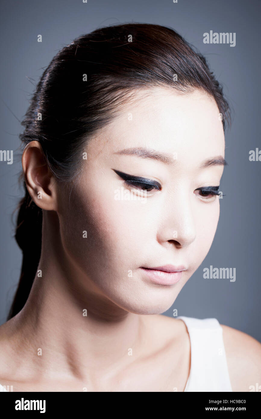 Portrait of young woman looking down Stock Photo - Alamy