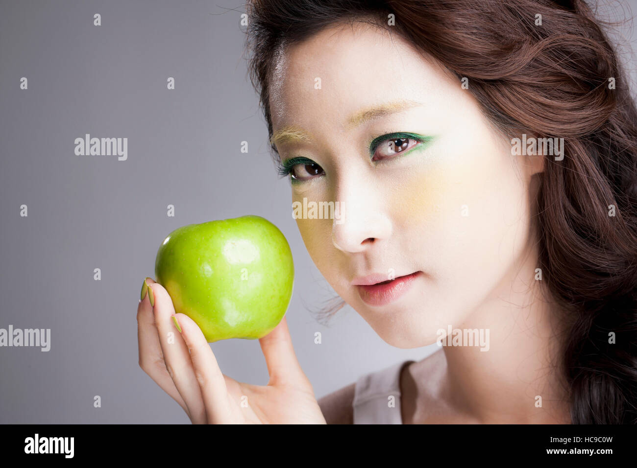 Portrait of young Korean woman with green apple Stock Photo - Alamy