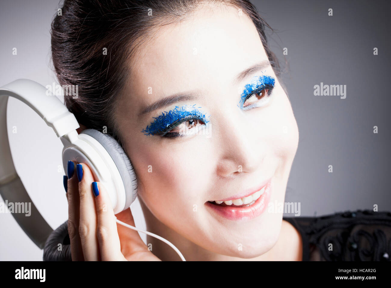 Portrait of young smiling Korean woman in blue eye shadow Stock Photo ...