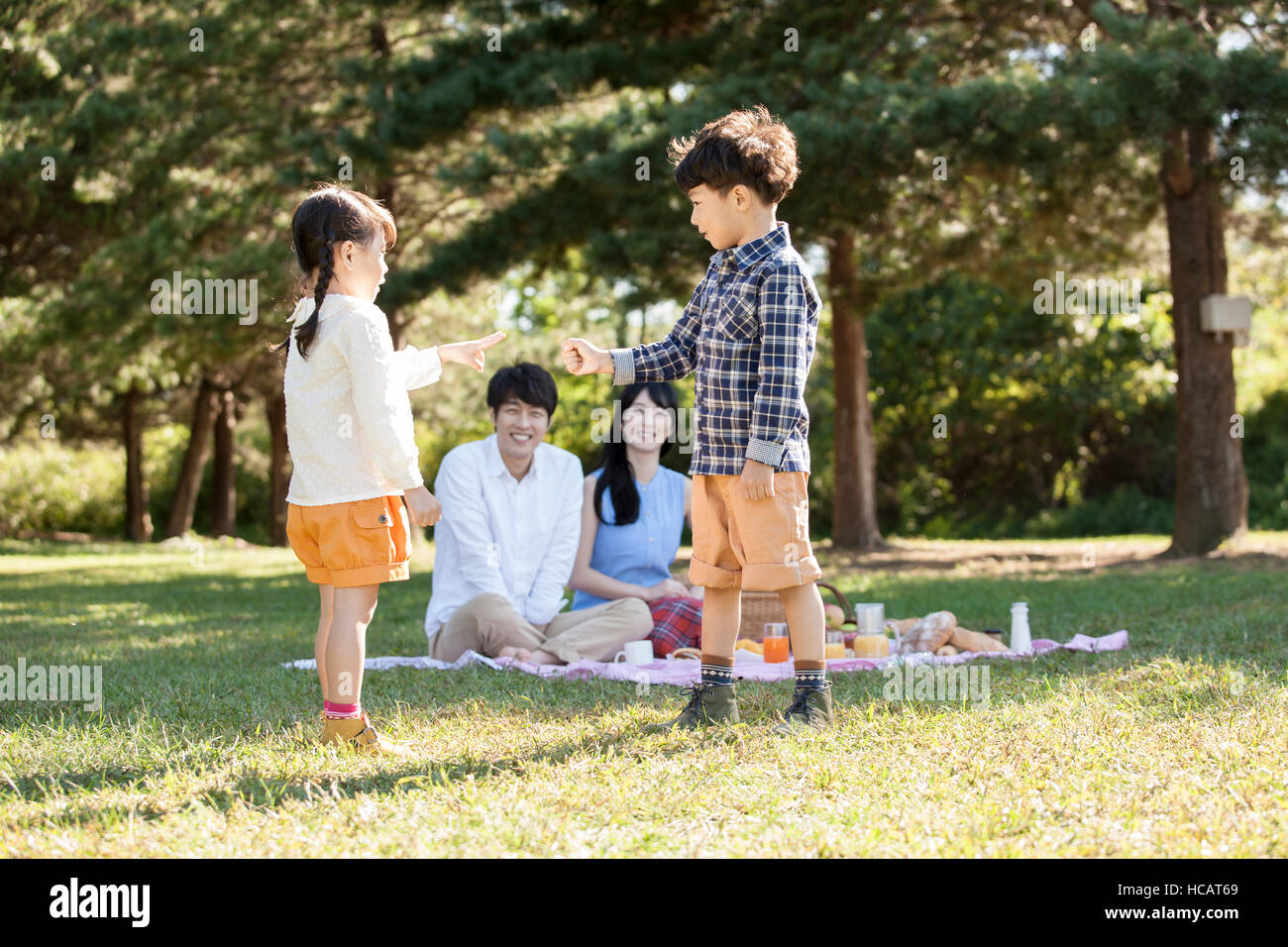 Harmonious family having a picnic under trees Stock Photo - Alamy