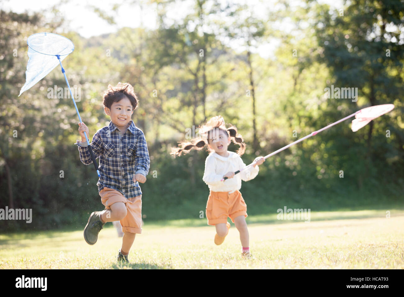 Smiling boy and girl with nets running outdoors Stock Photo - Alamy