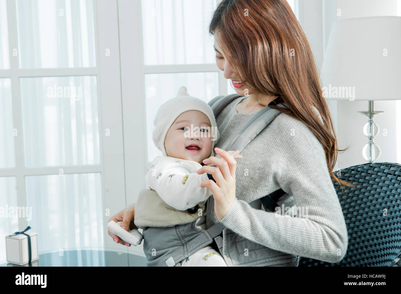 Portrait of smiling woman hugging a baby Stock Photo - Alamy