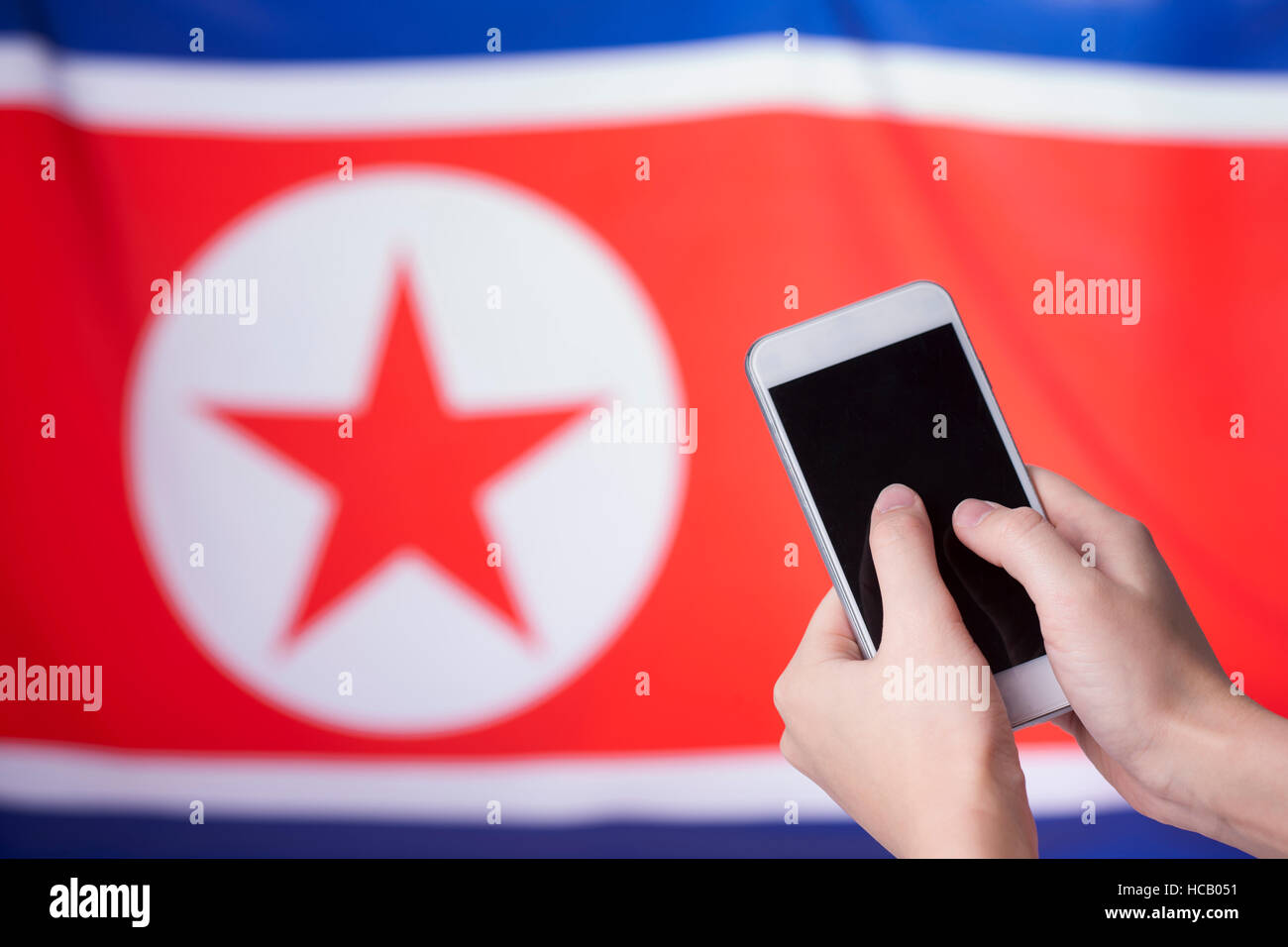 Hand holding a smartphone against the north Korean flag Stock Photo - Alamy