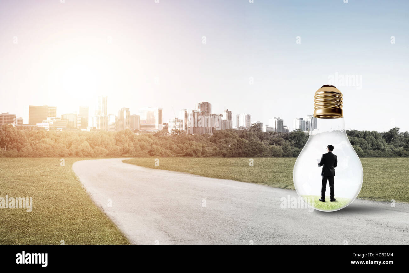 Businessman inside light bulb Stock Photo - Alamy