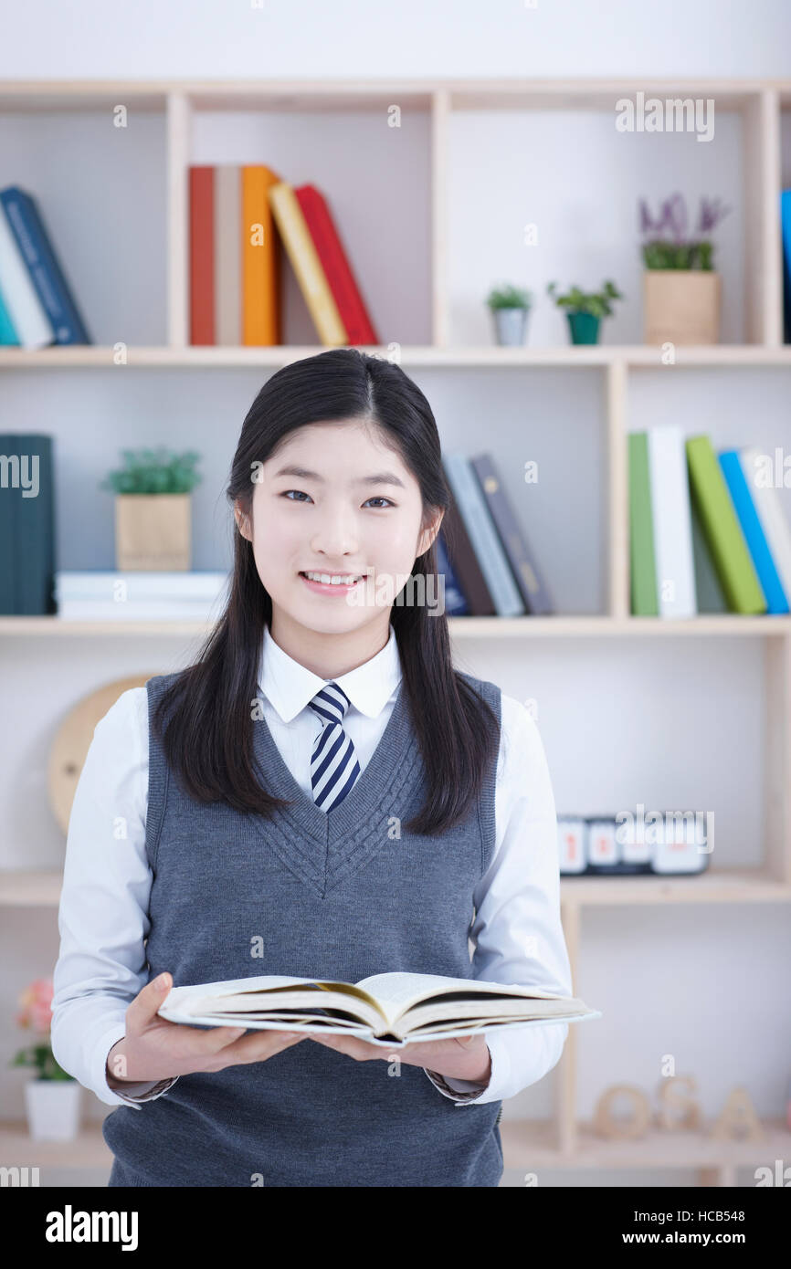 Portrait of smiling middle school girl with a book Stock Photo - Alamy