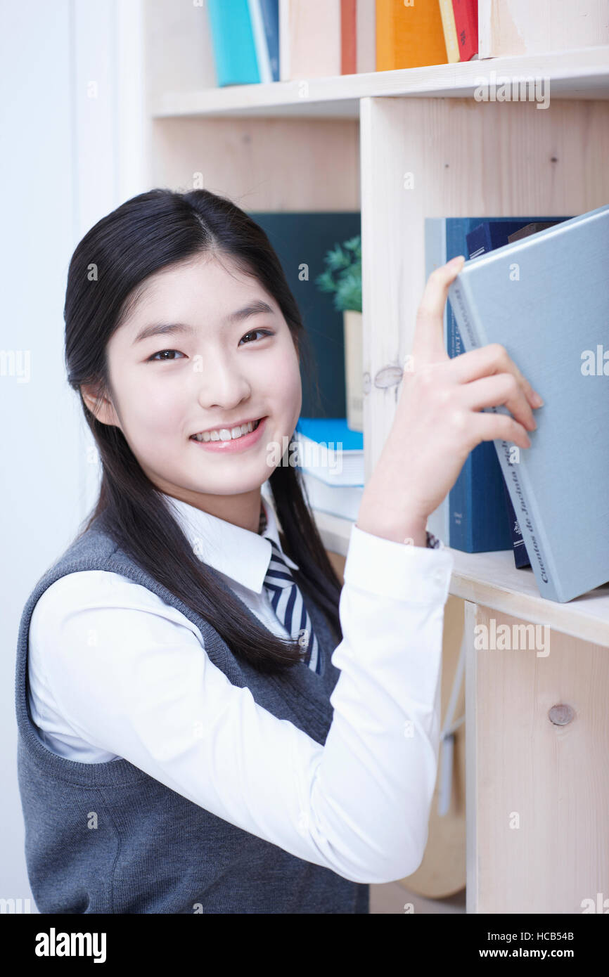 Portrait of smiling middle school girl choosing a book Stock Photo - Alamy