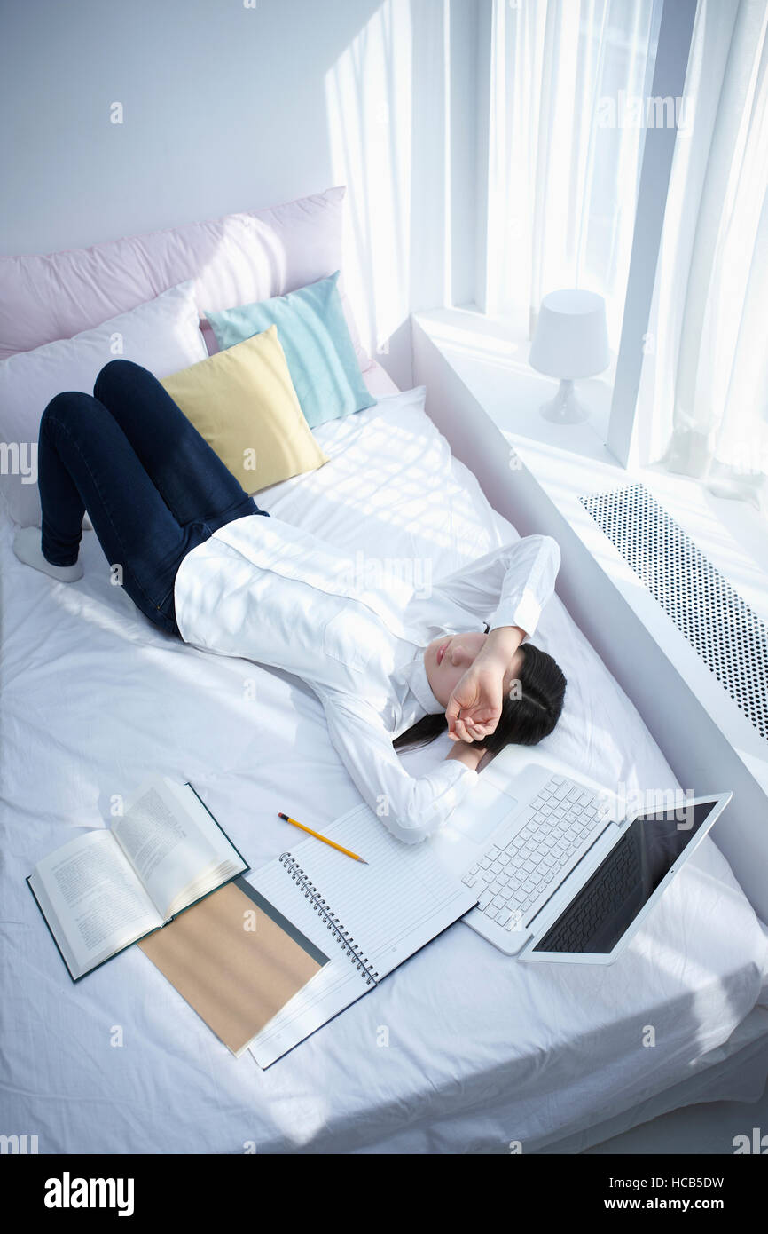 Middle school girl sleeping on bed with a notebook computer Stock Photo ...
