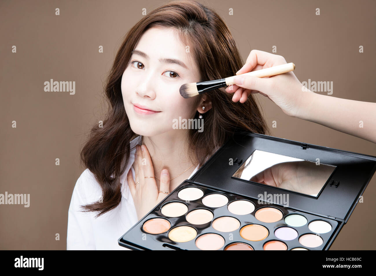 Portrait of young woman putting on makeup Stock Photo - Alamy