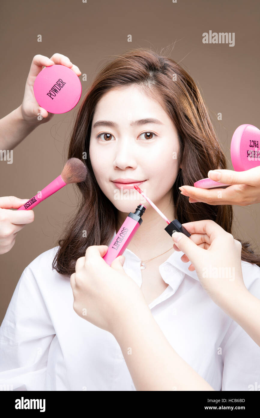 Portrait of young woman putting on makeup up Stock Photo - Alamy