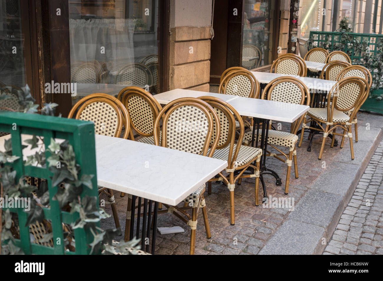 Wicker chairs and white tables outdoor cafe in downtown Stock Photo - Alamy