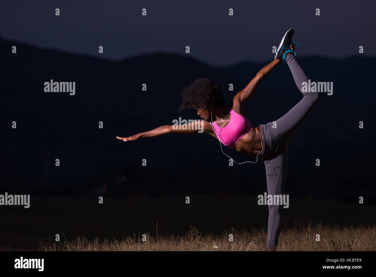 young beautiful black woman doing yoga exercises in the nature of a ...